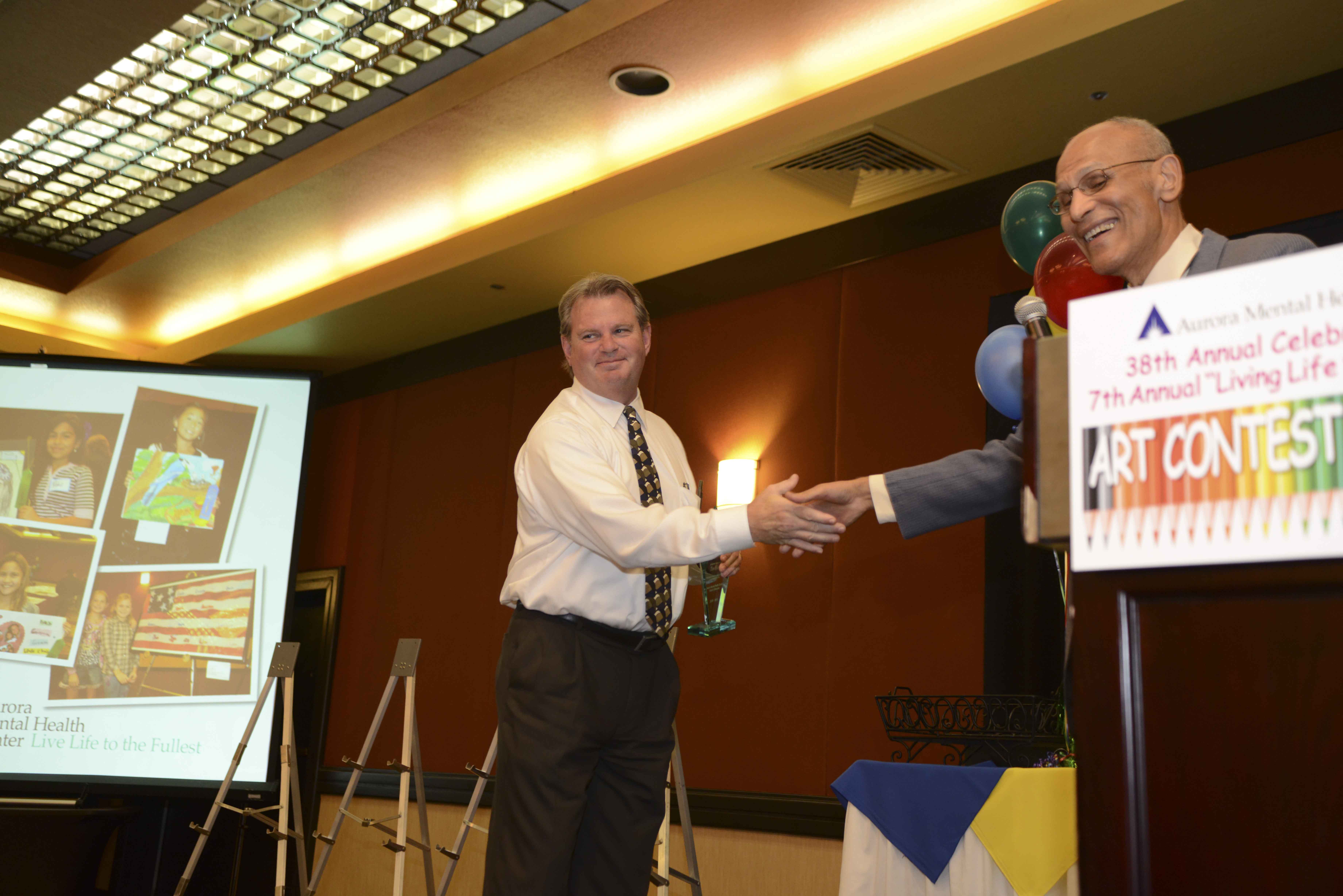 Retiring board member Tim Hand accepts his award