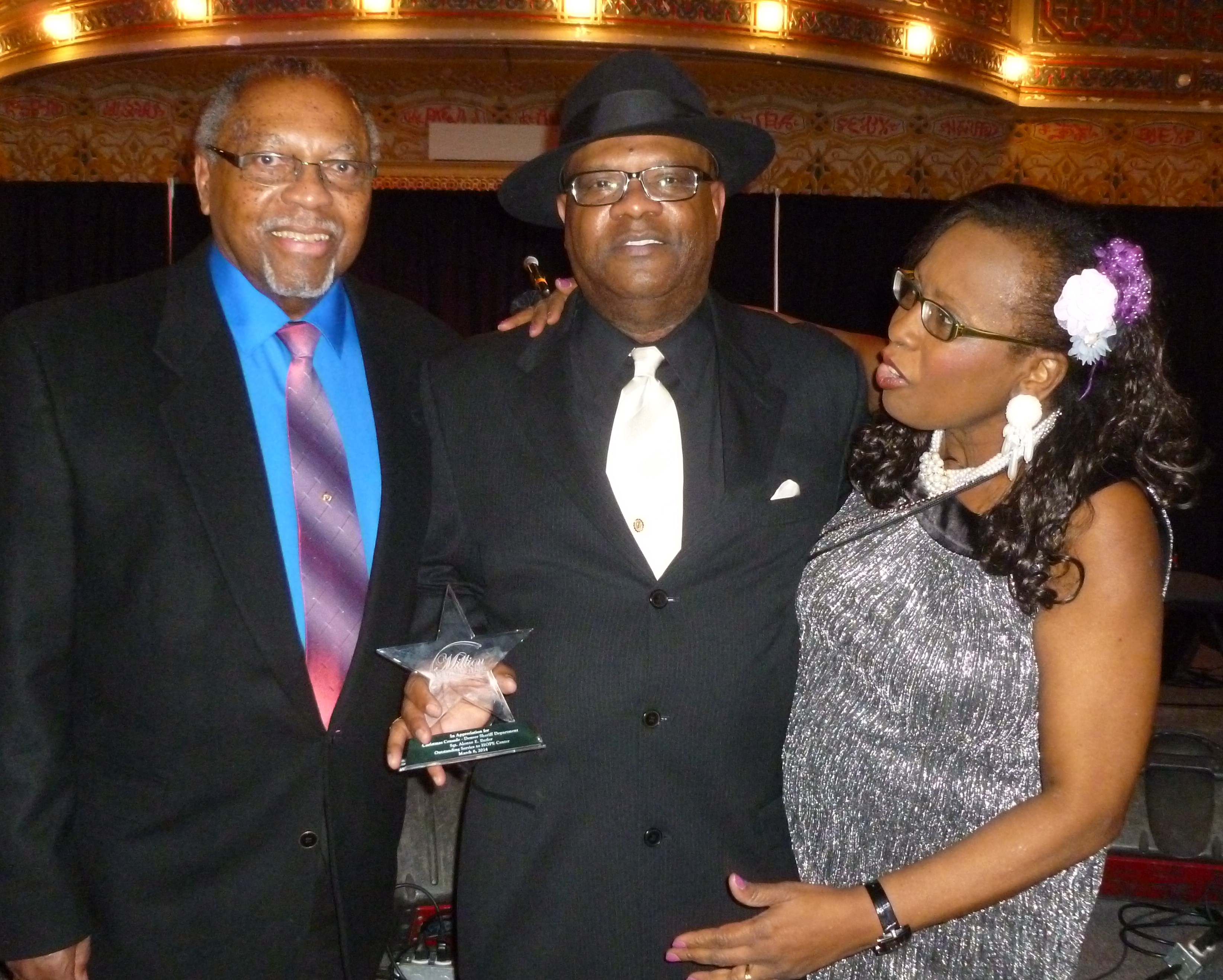 Sgt. Alonzo Butler (center) accepts an Outstanding Service Award for ...
