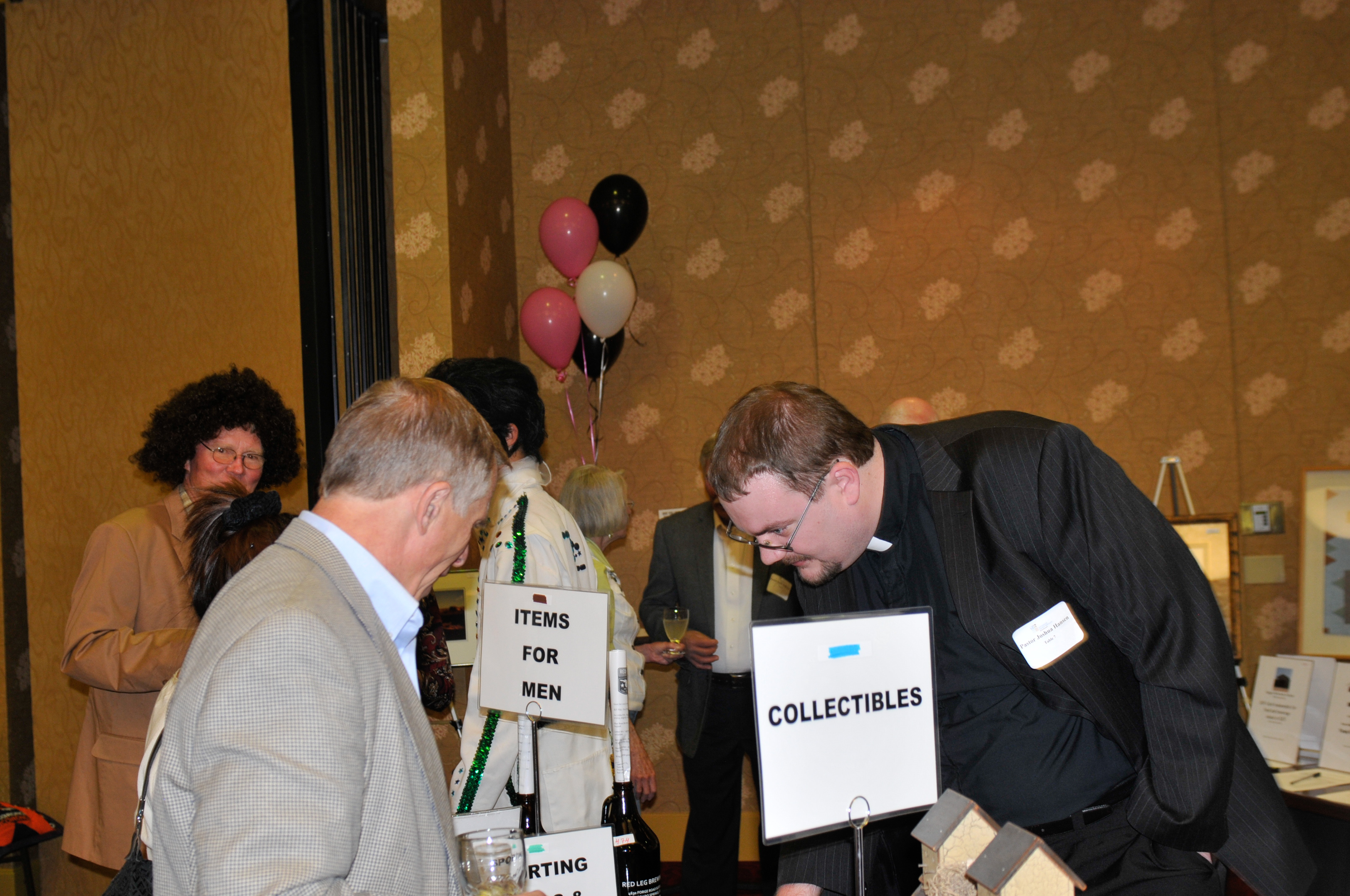 Greg Gast and Pastor Joshua Hansen look at auction offerings