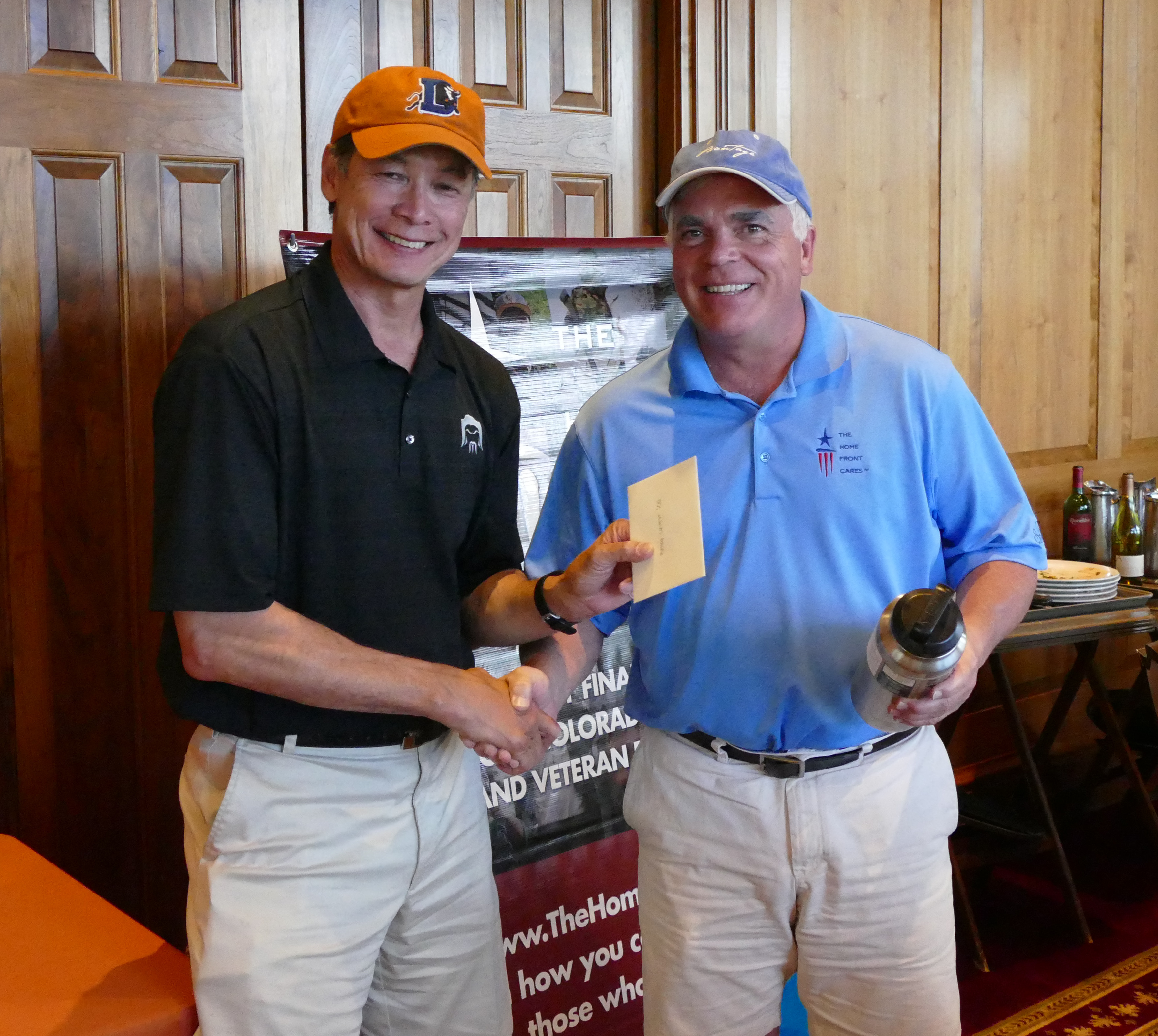 Jay Warwick gives Danny Mientka his prize for winning the putting contest