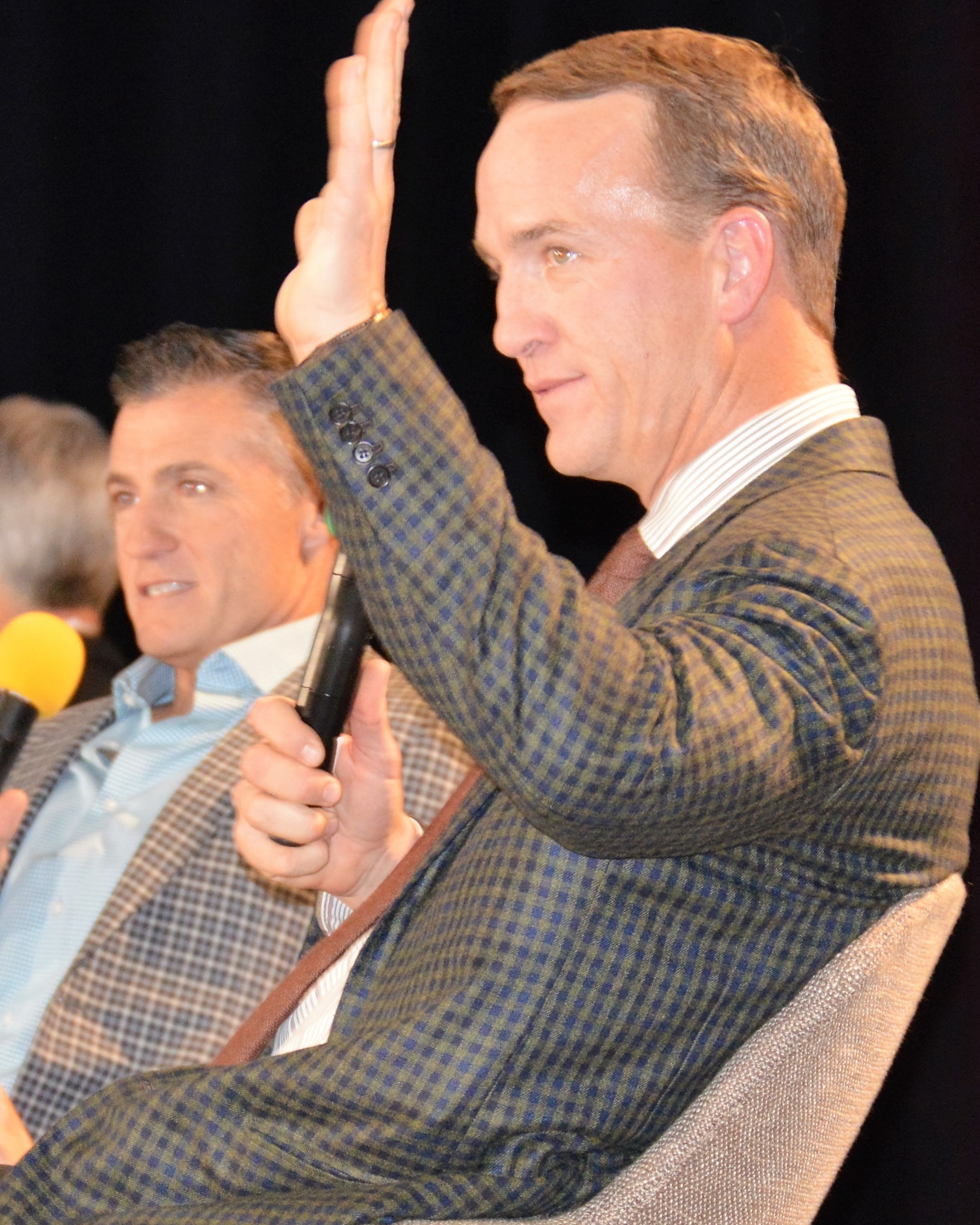 Peyton Manning greets the crowd, with Vic Lombardi (left).