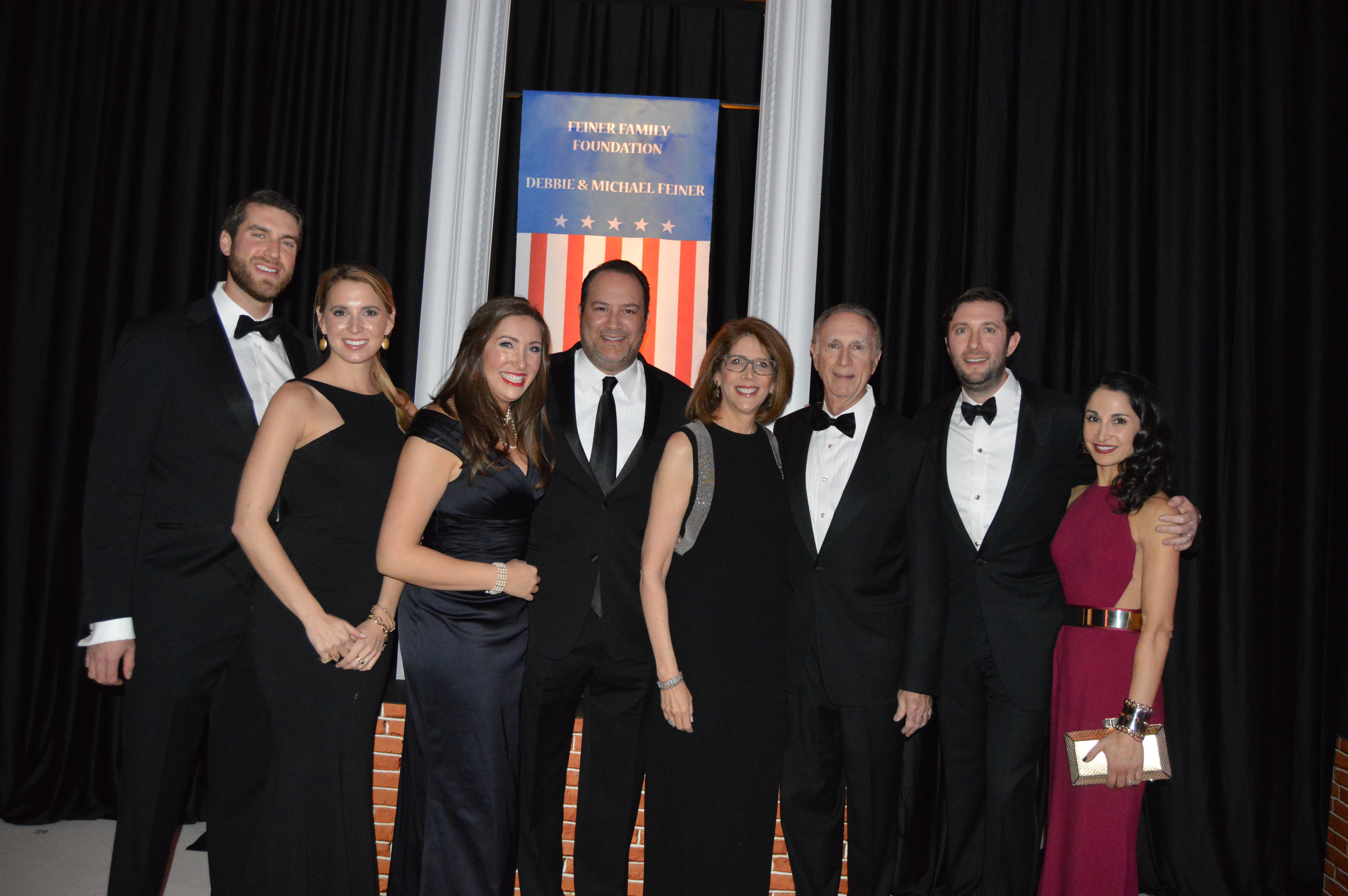 Feiner family members pose in front of the Feiner Family Foundation banner.