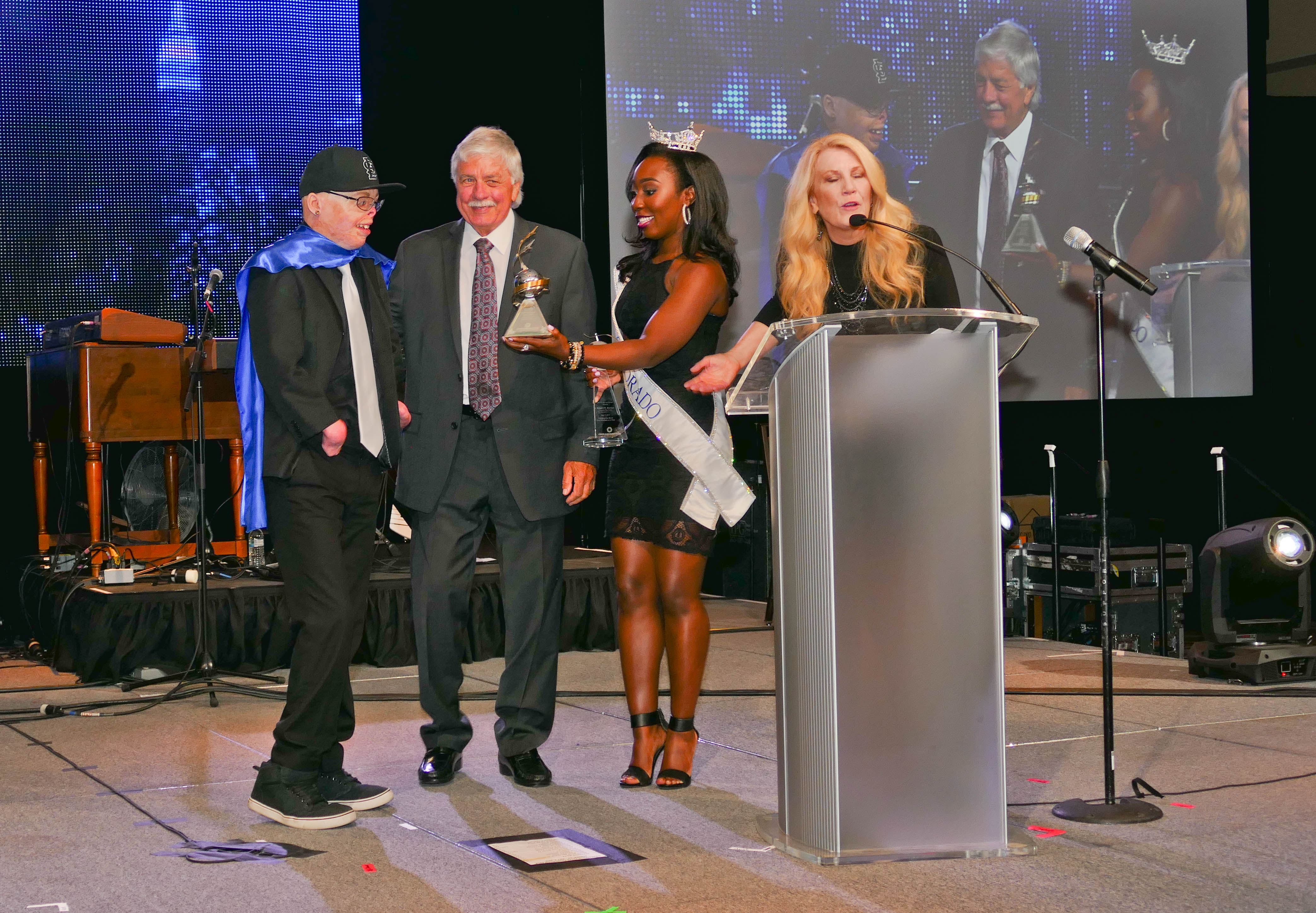 Honorees Johnny Quinn and Robert Barron on stage with Miss Colorado ...