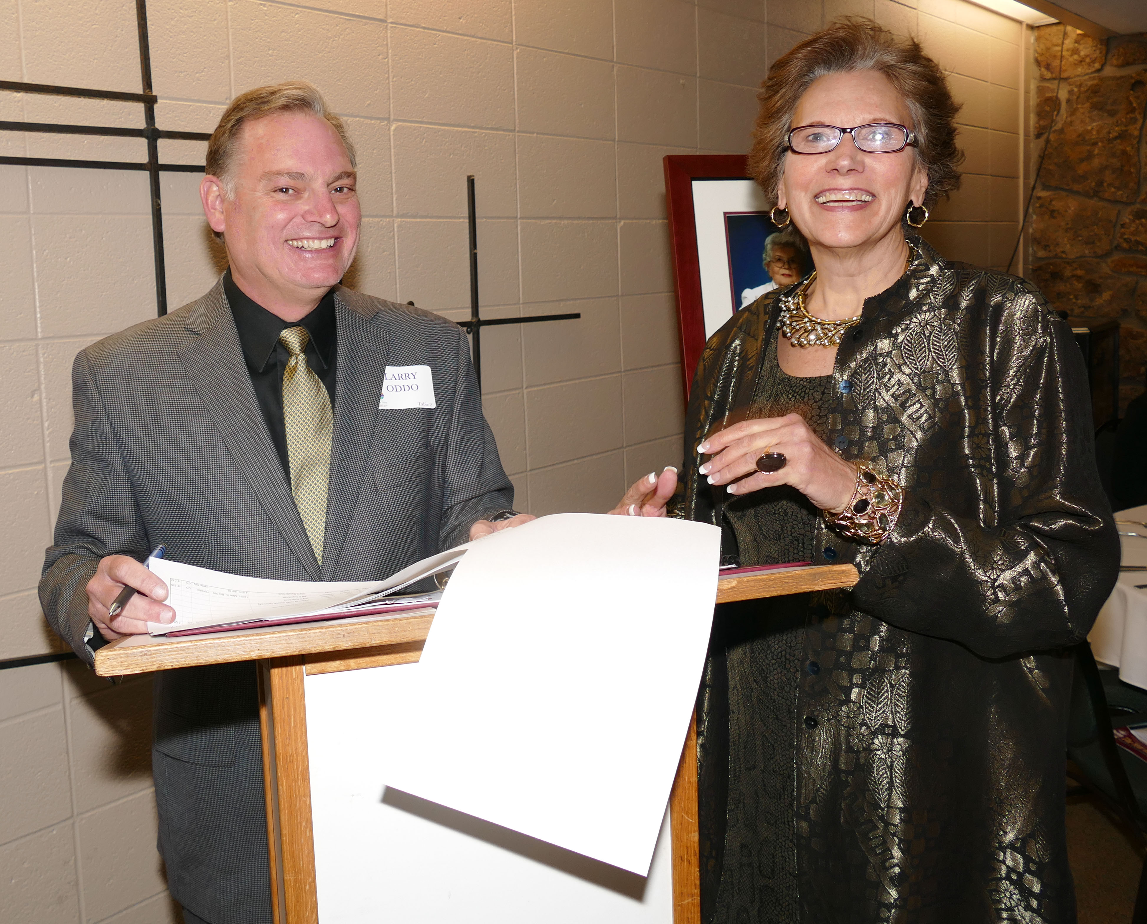 Emcee Larry Oddo and Foundation Director Martha Simmons compare notes ...