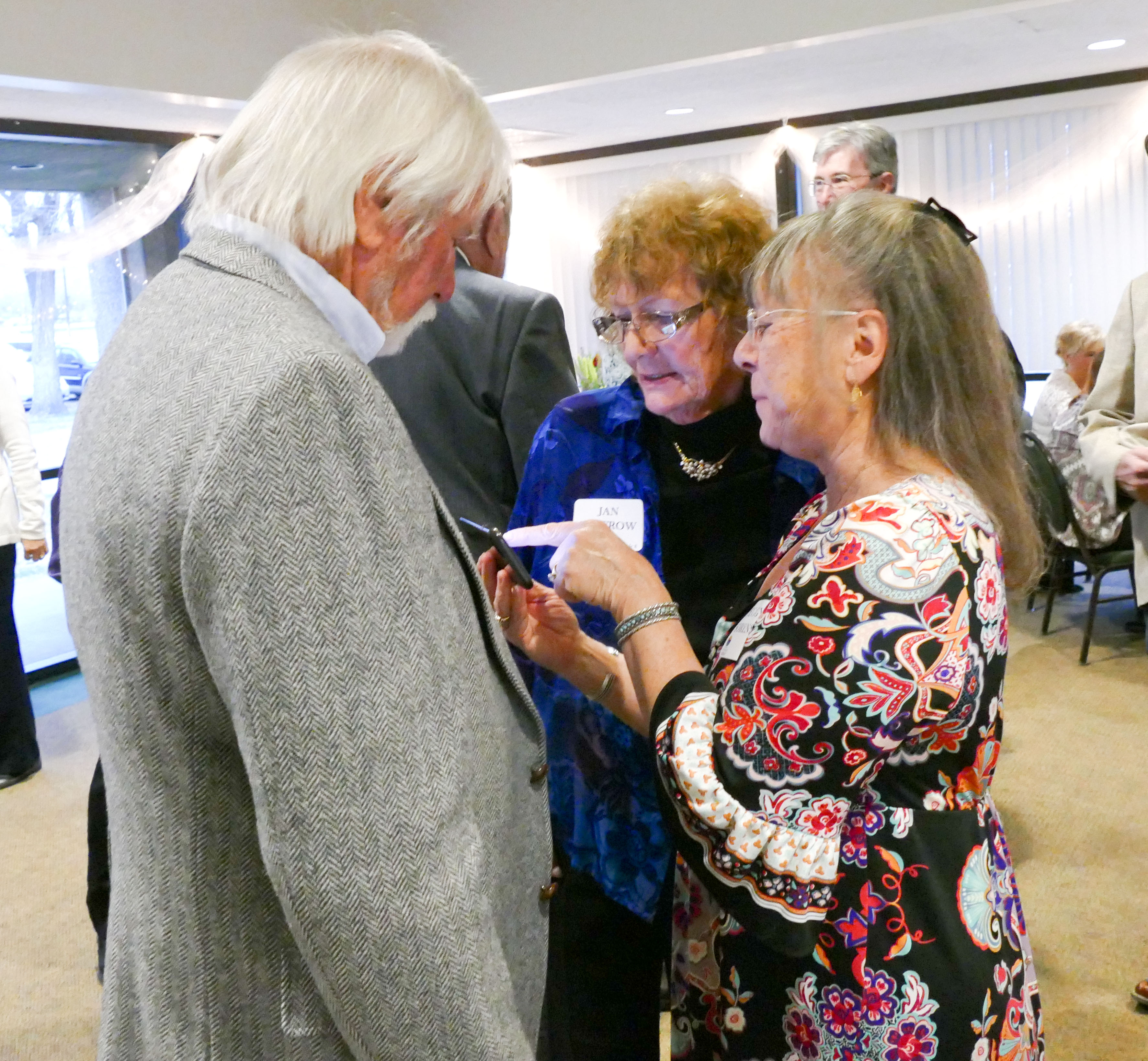Curt Sorenson, left, Jan Renfrow and Peggy Sorenson look at a cellphone ...