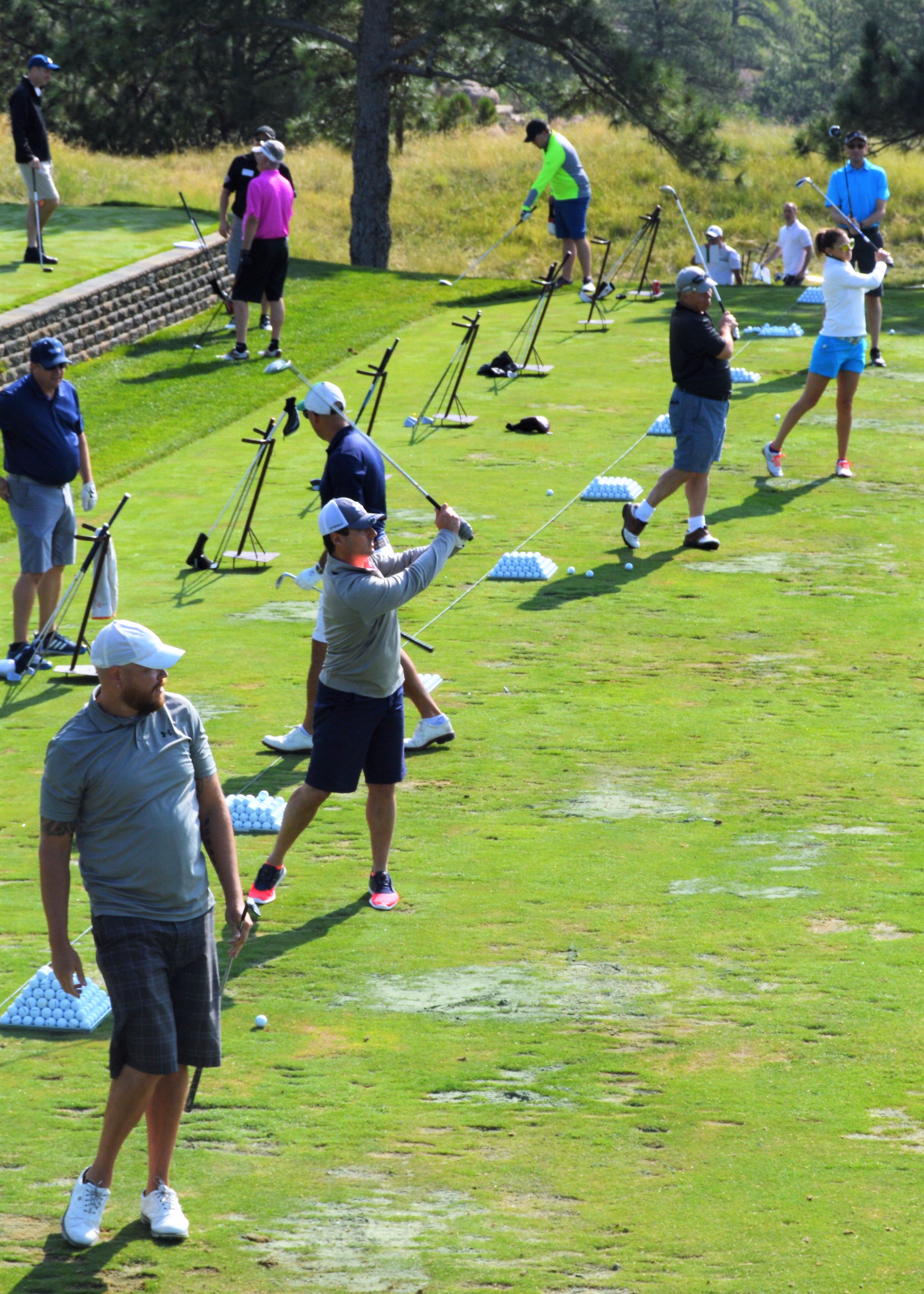 Golfers take time to warm up on the driving range