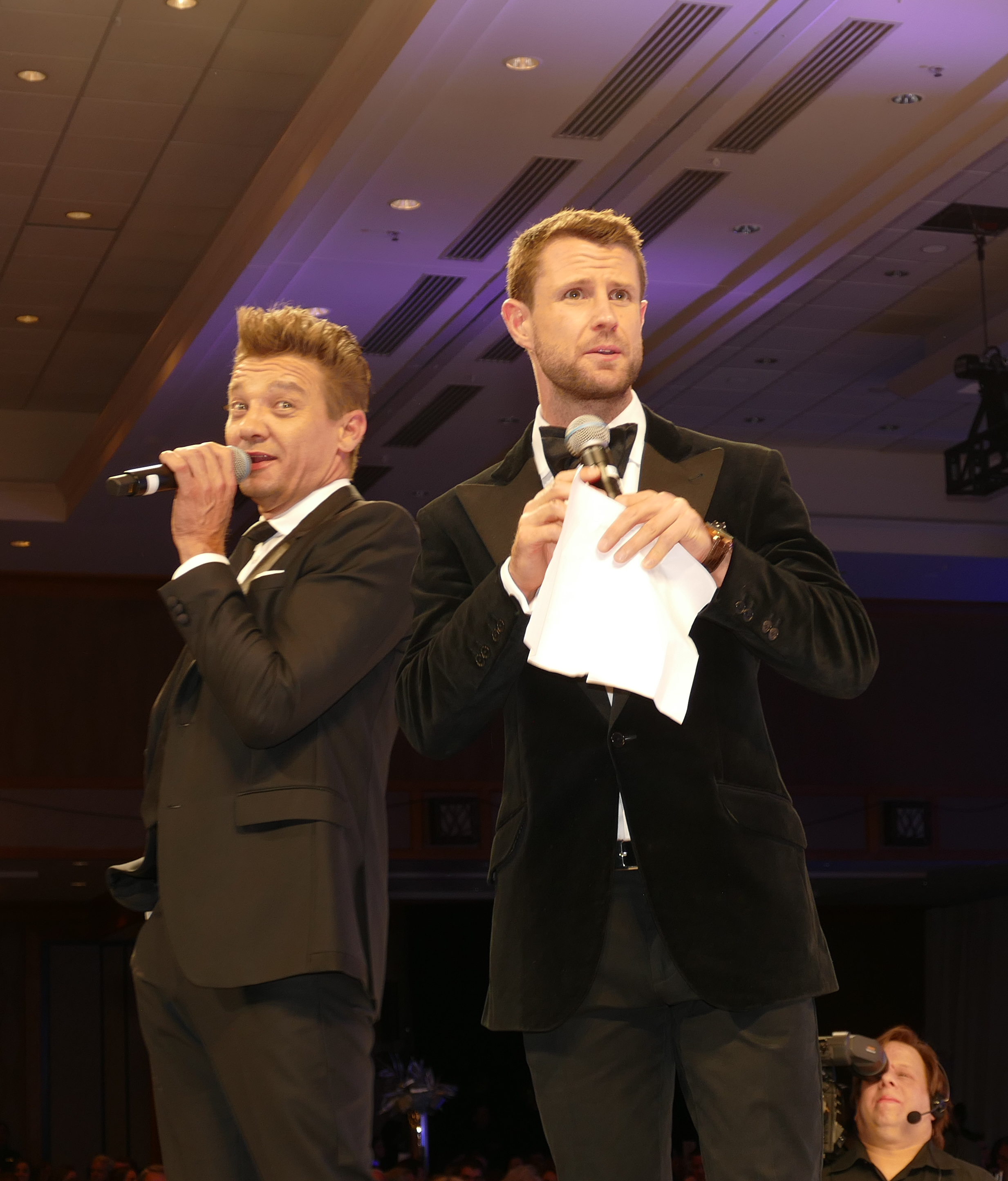 Actor Jeremy Renner on stage with the auctioneer, offering up tickets ...