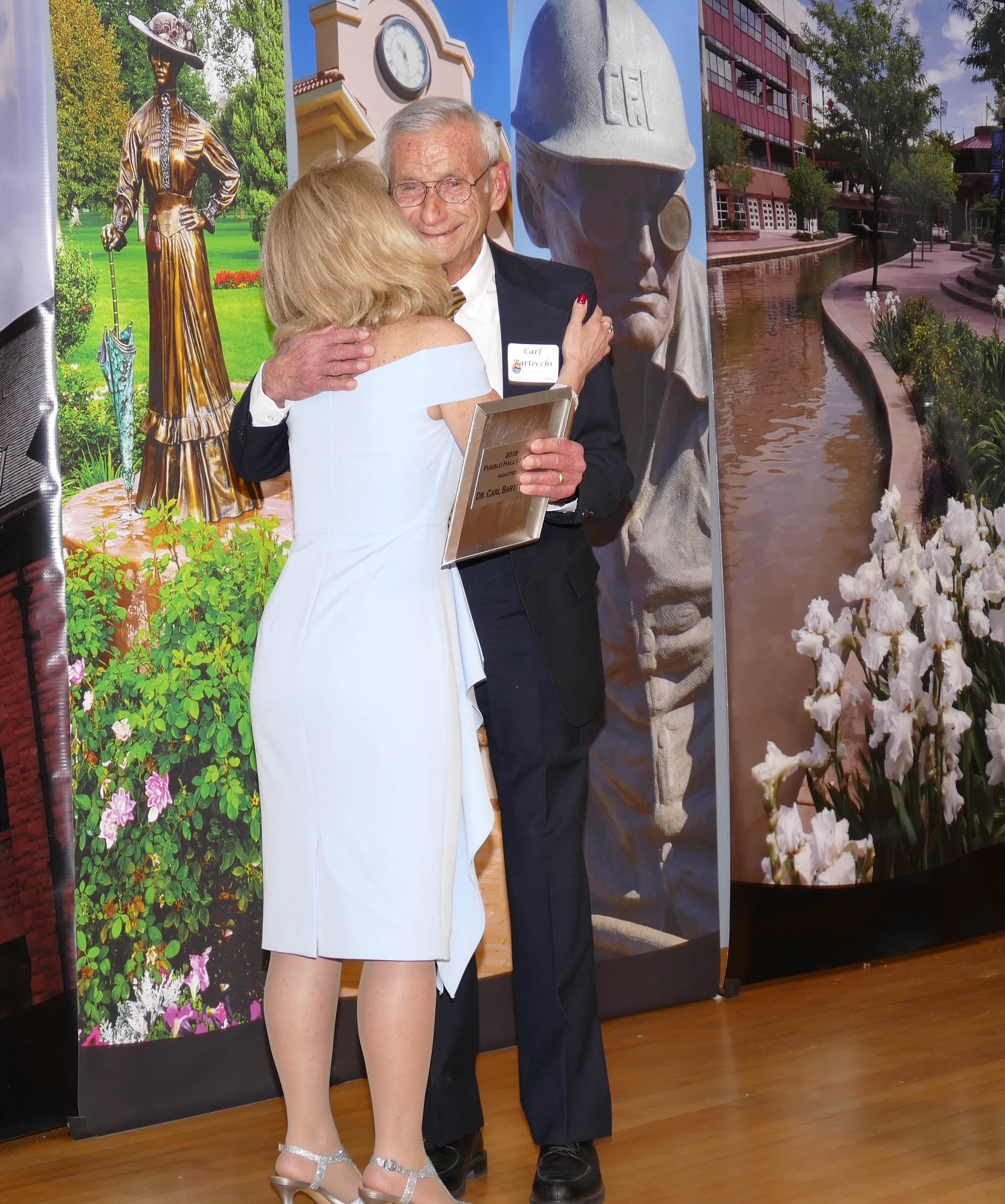Dr. Carl Bartecchi gets a hug from Dr. Patty Erjavec