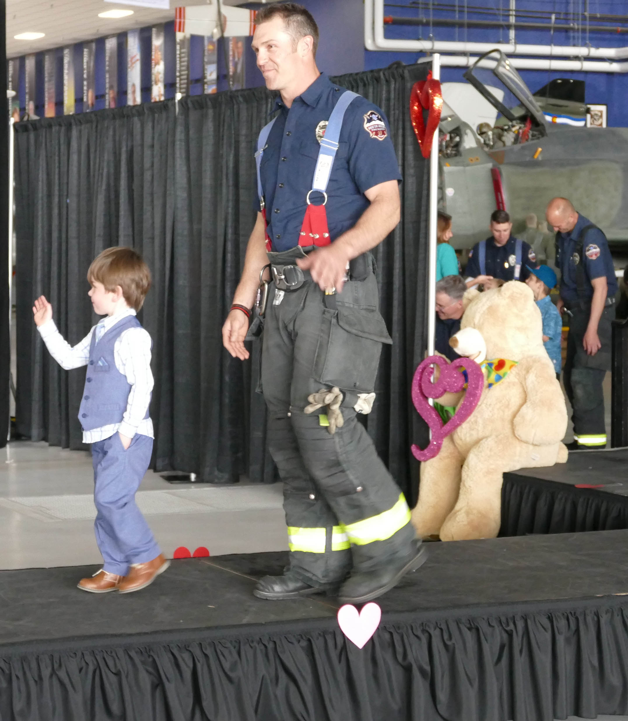 Cameron waves to the crowd, with firefighter Brett Miller