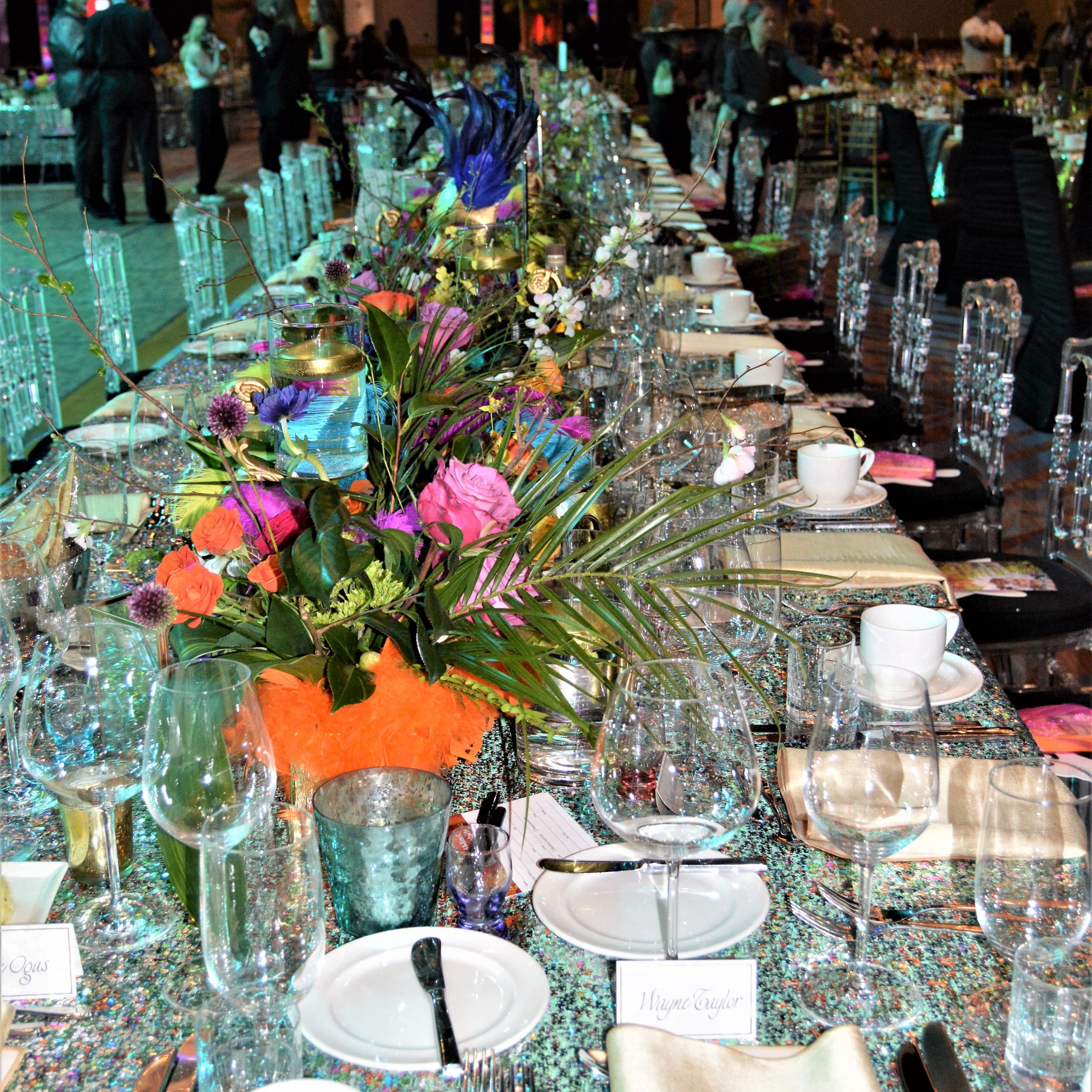 A VIP table is prepared for the dinner program with florals by Design ...