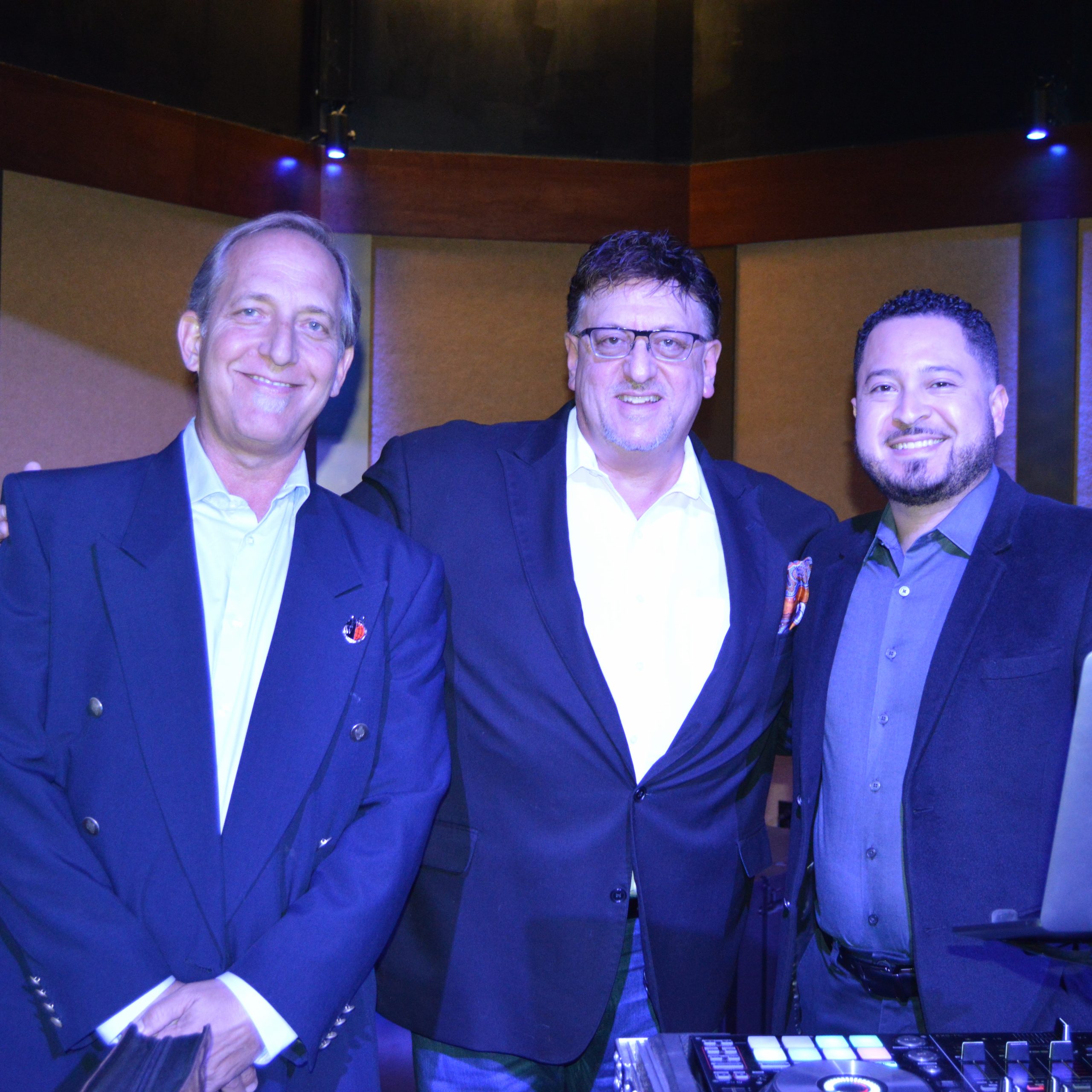 Basking in festive blue lights (l to r): Larry Cohen, auctioneer Jim ...